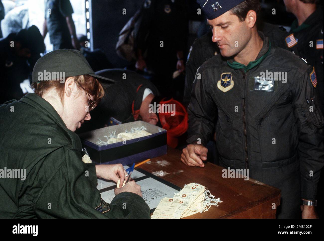 A1C Sandra Whipps checks in CPT Richard Keller at the bag and weight ...