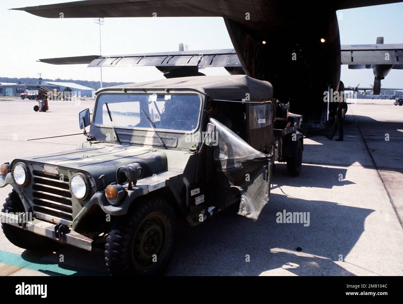 Air Force personnel back an M-151A2 jeep into the cargo hold of a C-130 ...