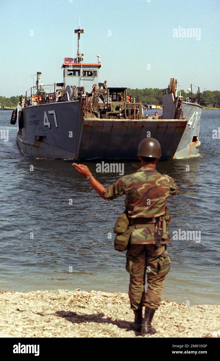 The US Army Utility Landing Craft LCU 1547 is guided to a landing on ...