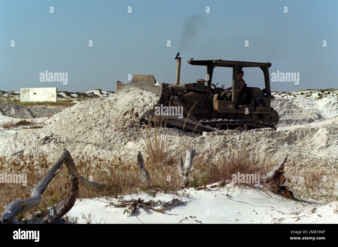 A bulldozer is used to excavate a sand berm that will hold a fuel ...