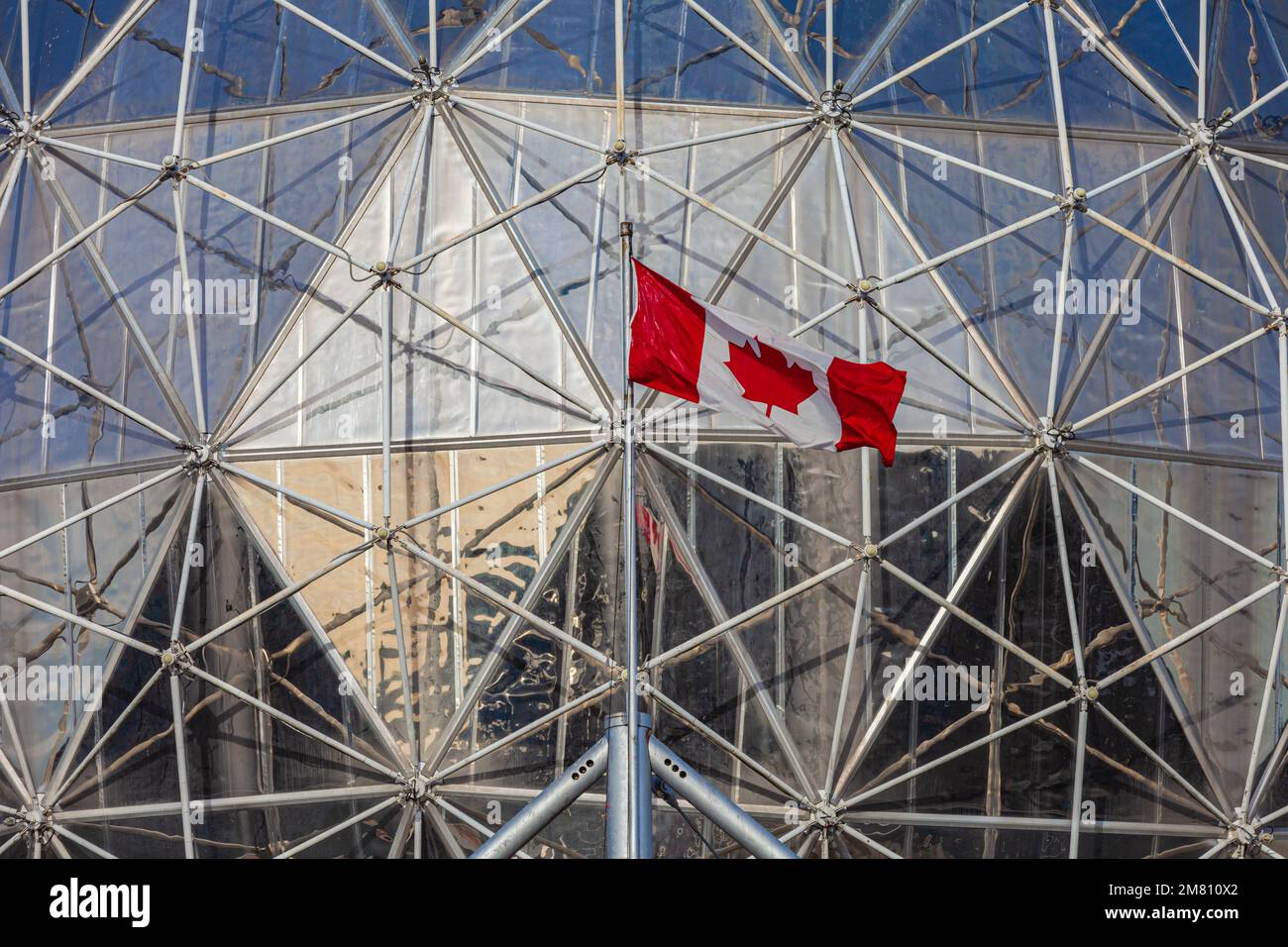 Canadian flag against the geodesic dome of the BC Science Centre in ...