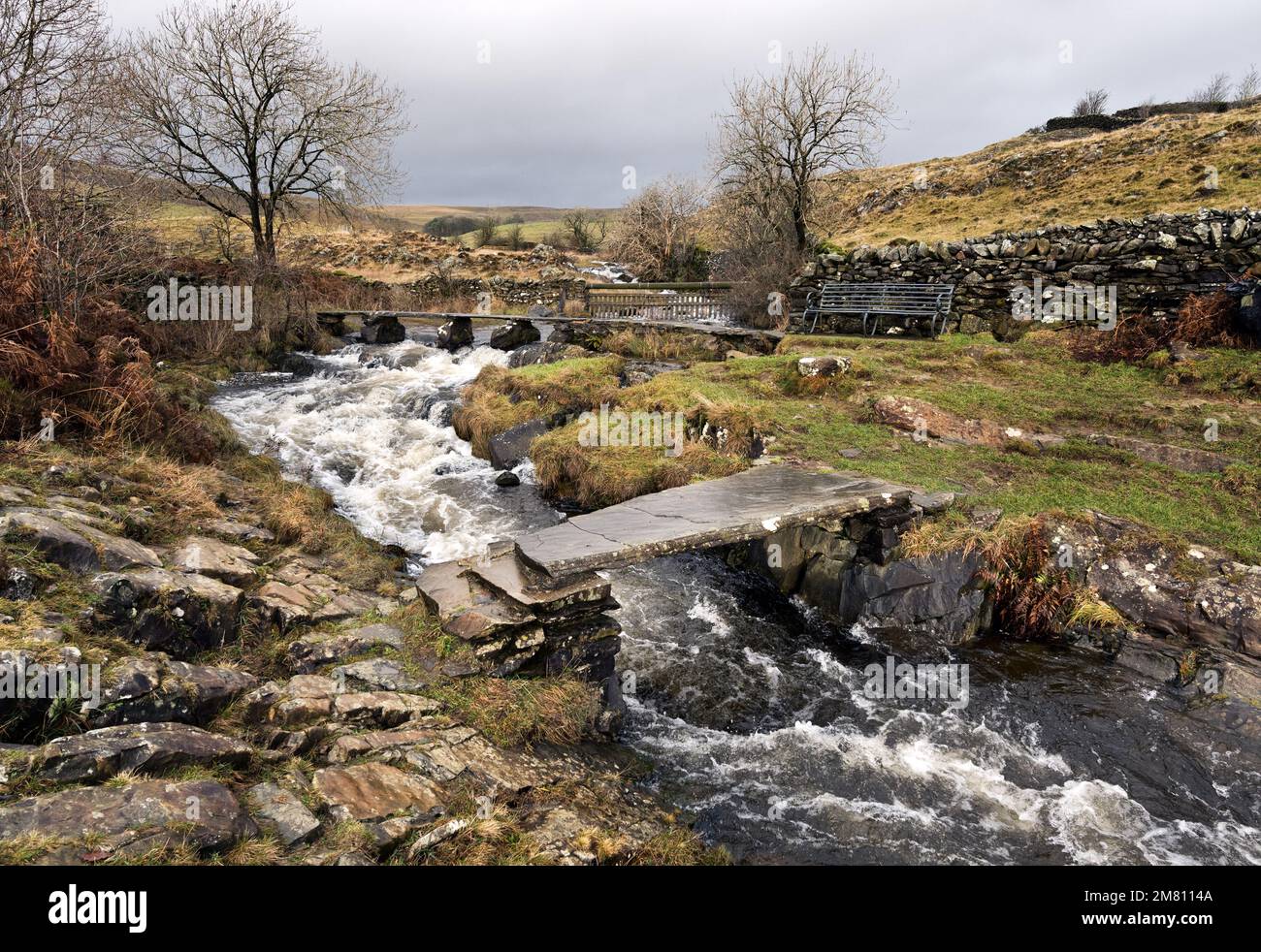 Heavy rain swells the stream flowing under the old clapper bridges in ...