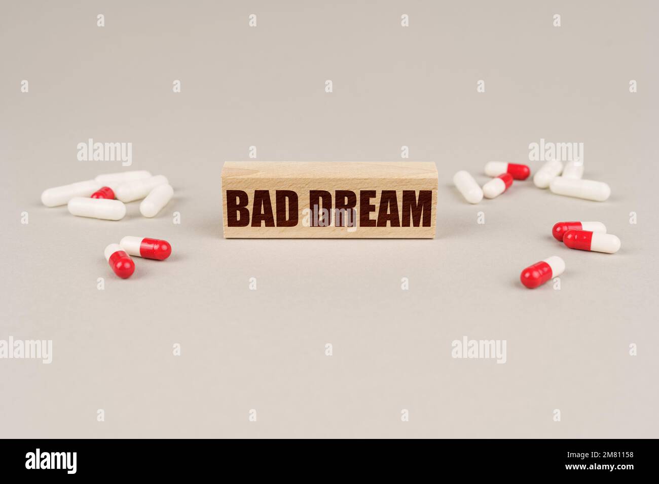 Medical concept. On a gray surface are tablets, capsules and a wooden ...