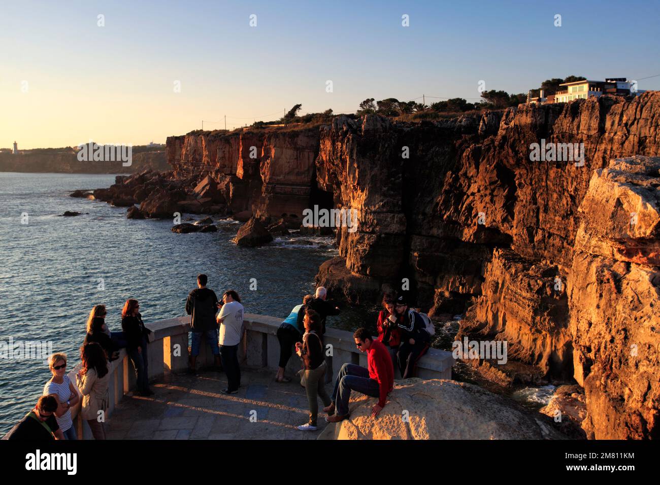People watching the sunset over the Atlantic Ocean at Boca do Inferno ...