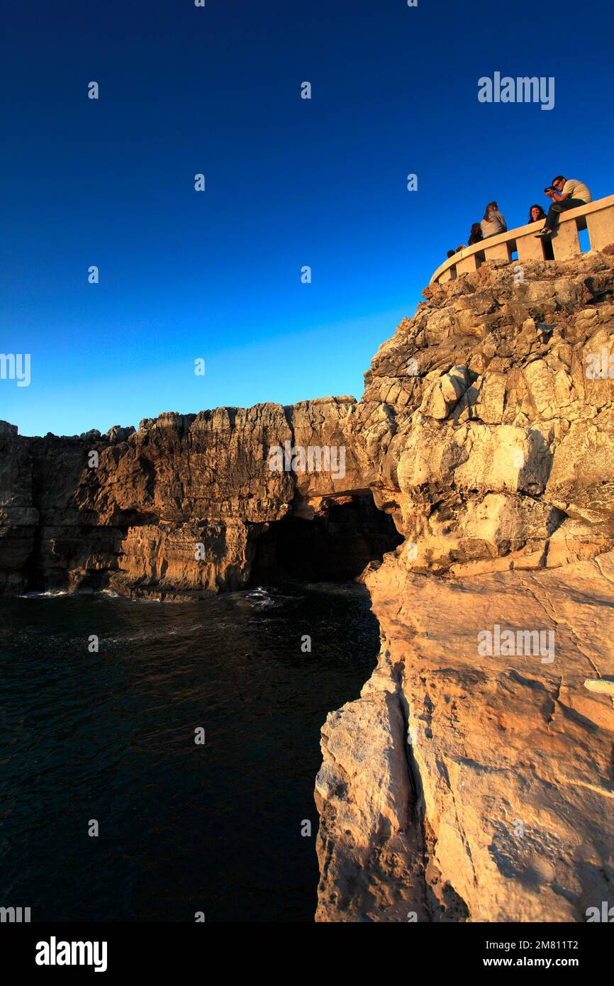 People watching the sunset over the Atlantic Ocean at Boca do Inferno ...