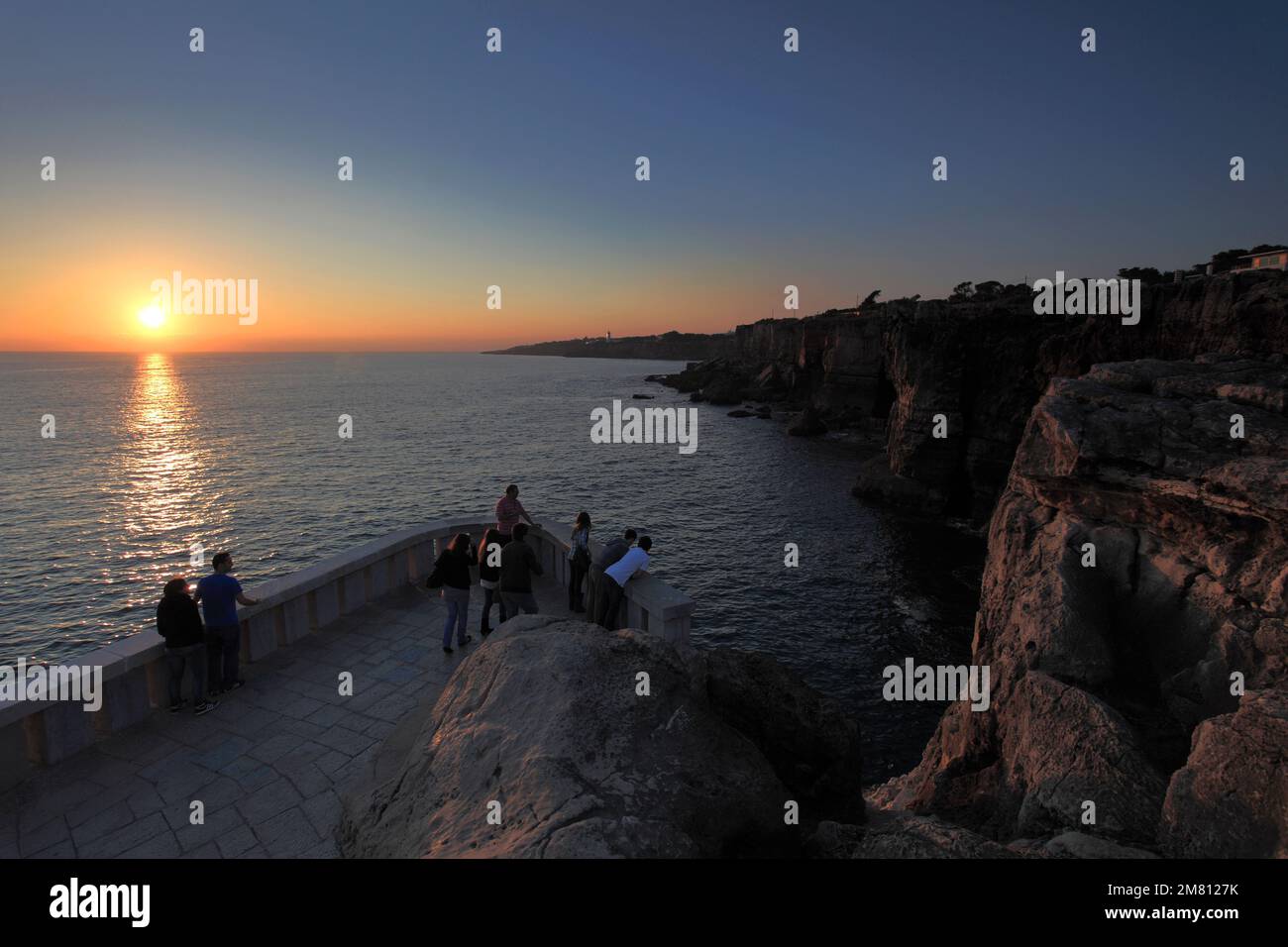 People watching the sunset over the Atlantic Ocean at Boca do Inferno ...
