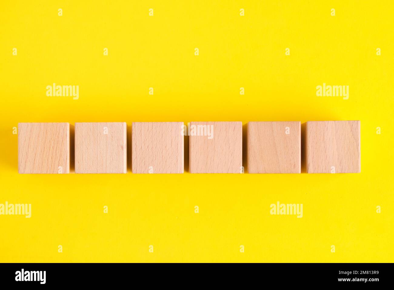 Beech wooden cubes yellow background Stock Photo - Alamy