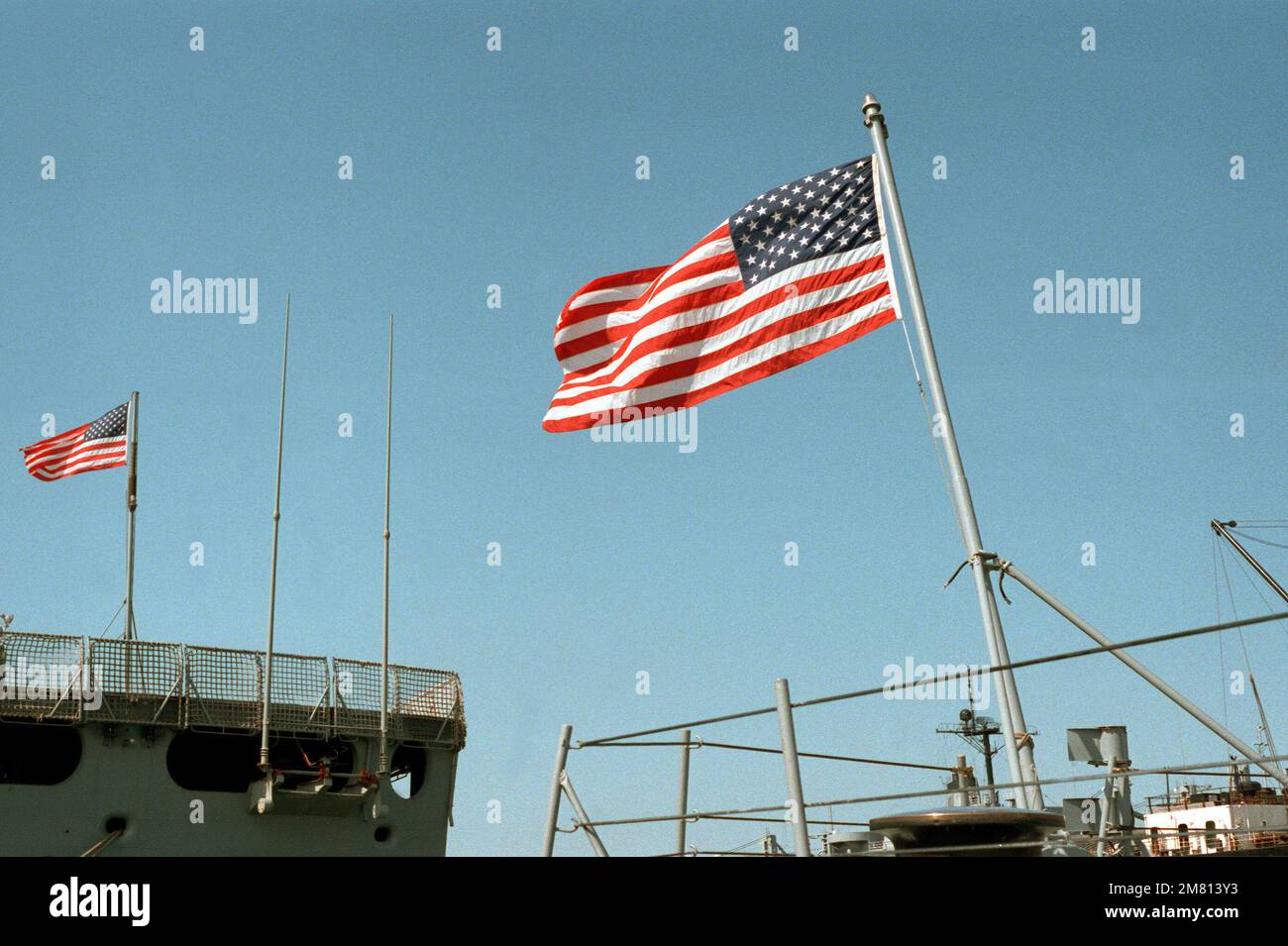 American flags fly at the sterns of the fast combat support ship USS ...