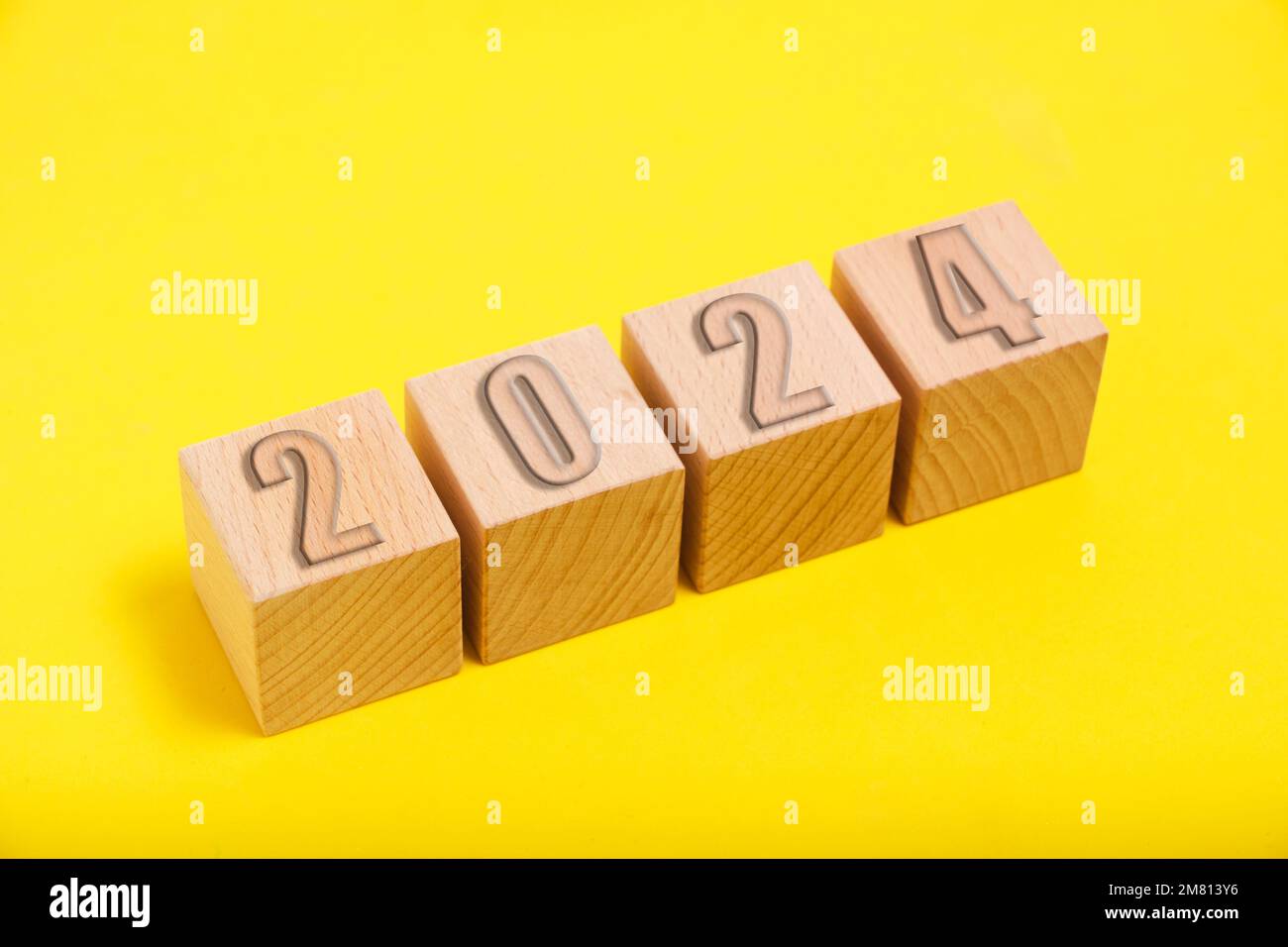 Wooden cubes with numbers 2024 yellow background Stock Photo - Alamy
