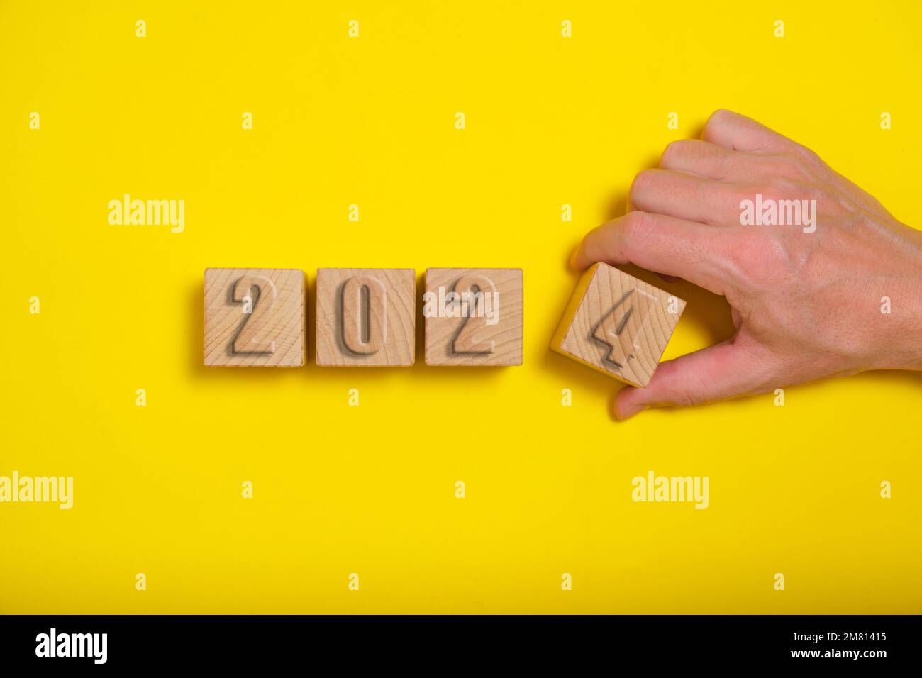 Wooden cubes with numbers 2024 yellow background are made by hand Stock ...