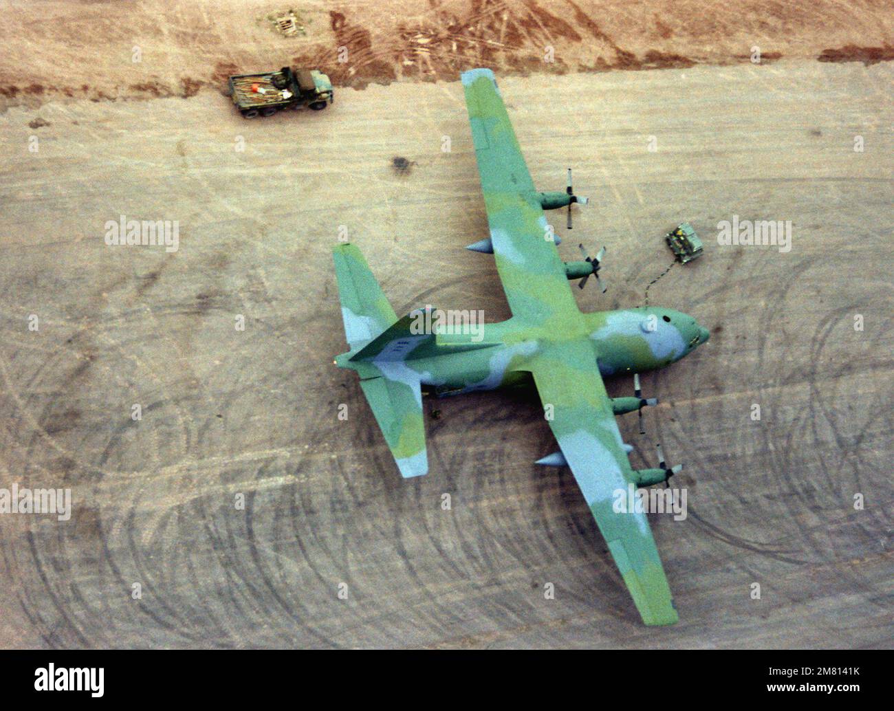 An aerial view of a camouflaged C-130E Hercules aircraft in use during ...
