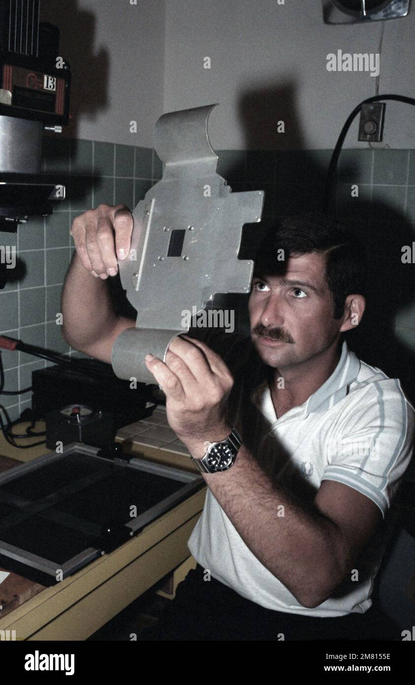 A photographer uses a print enlarger while processing film inside a lab ...