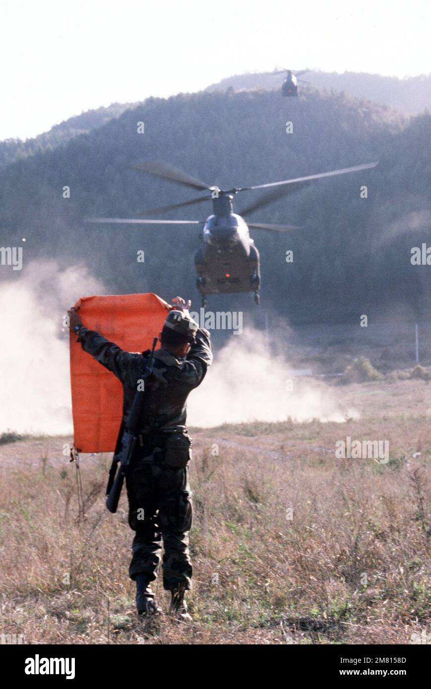 A Marine guided a CH-47 Chinook helicopter into a landing zone during a ...