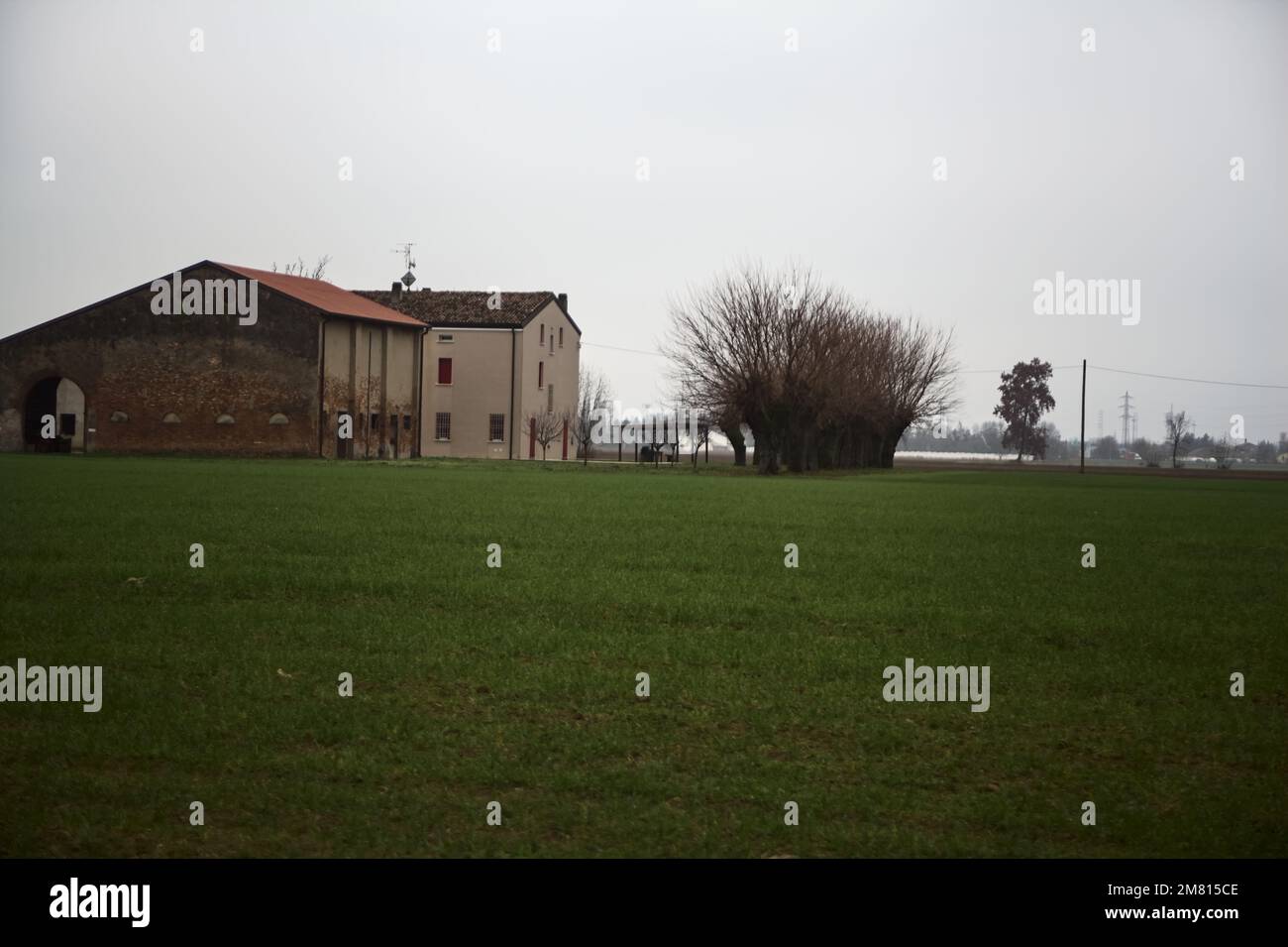 Country house in a field surrounded by trees on a cloudy day in the ...