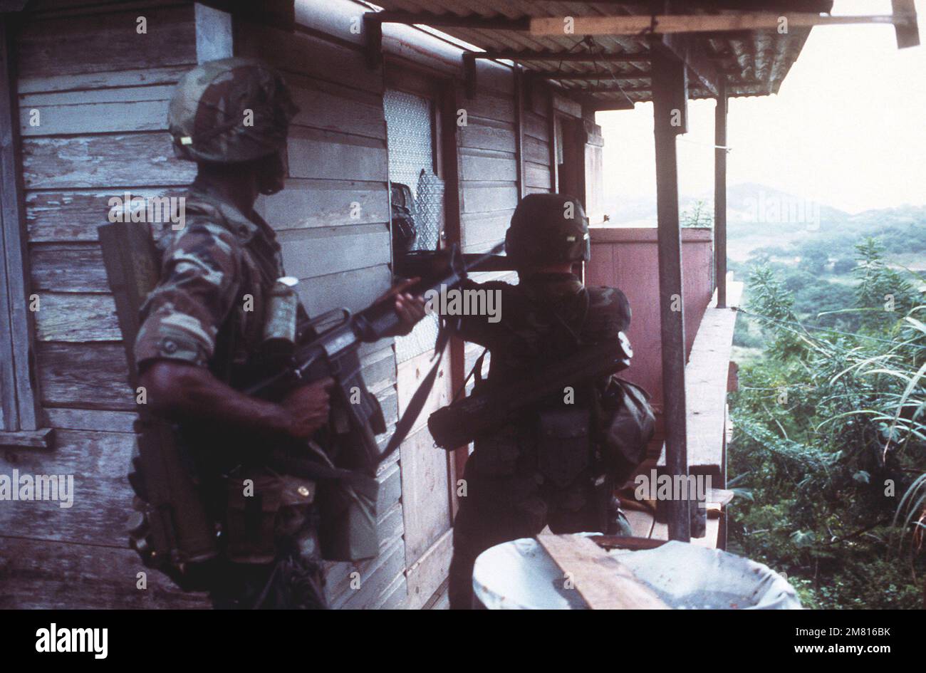 Members of the 82nd Airborne Division break into a building to conduct a search during Operation ...