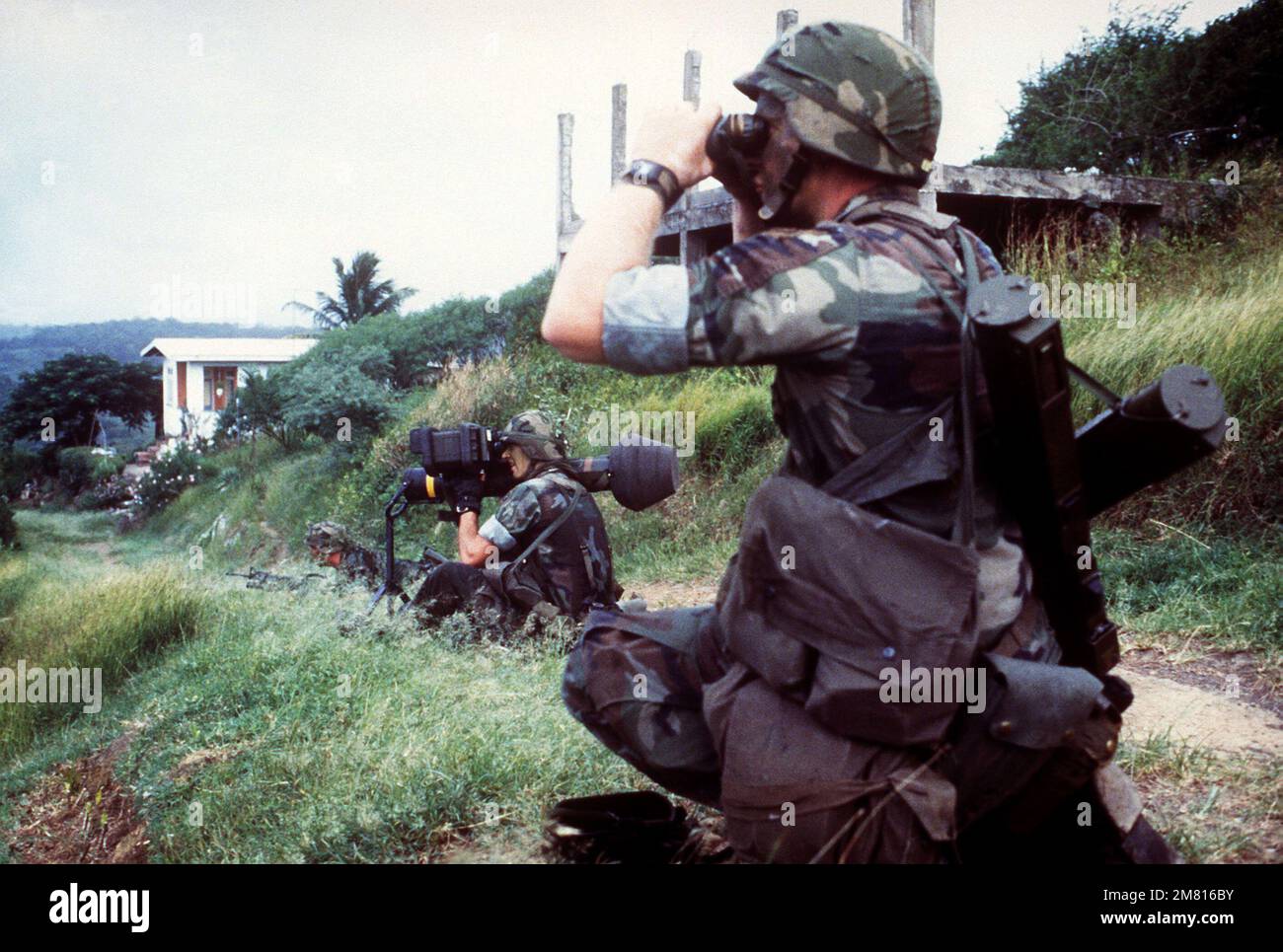 Members of the 82nd Airborne Division searches for targets while another soldier holds his M47 ...