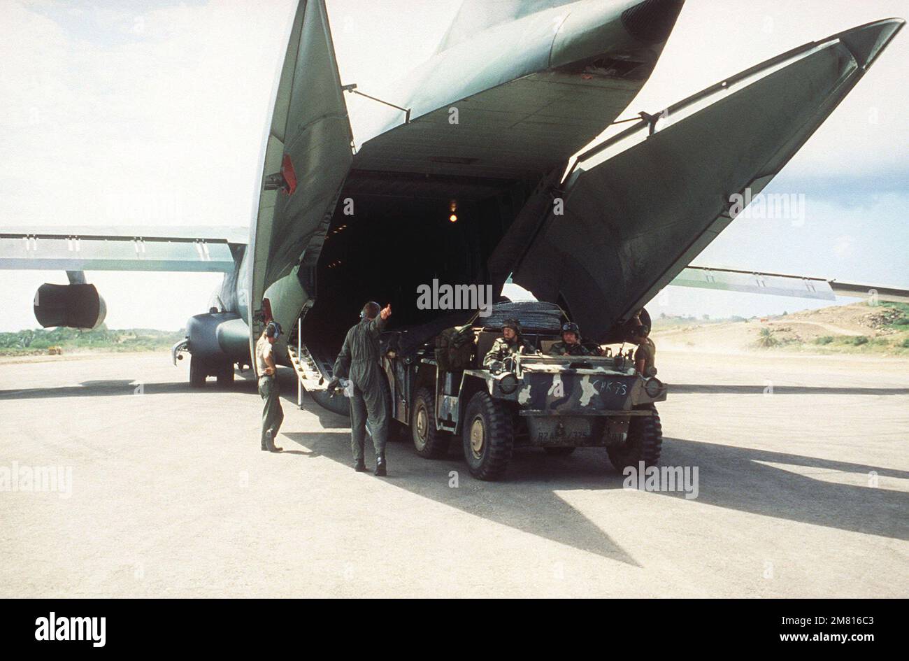 An M561 Gama Goat truck loaded with supplies prepares to pull away from ...