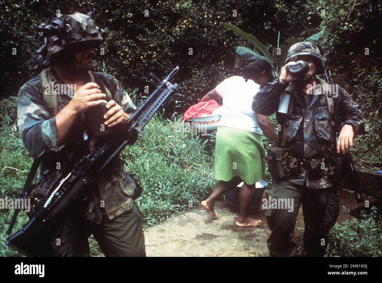 Members of the 82nd Airborne Division take a water break while on patrol during Operation URGENT ...