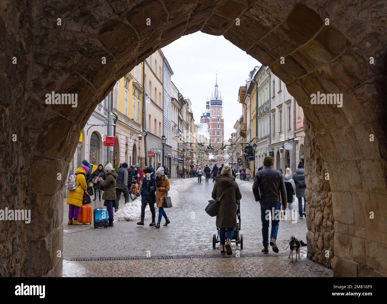Krakow Old Town; people walking through the arch gate in the medieval ...