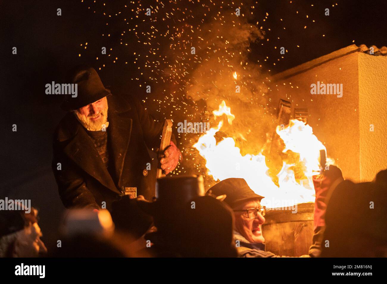 People carry a burning barrel of tar during the Burning of the Clavie ...