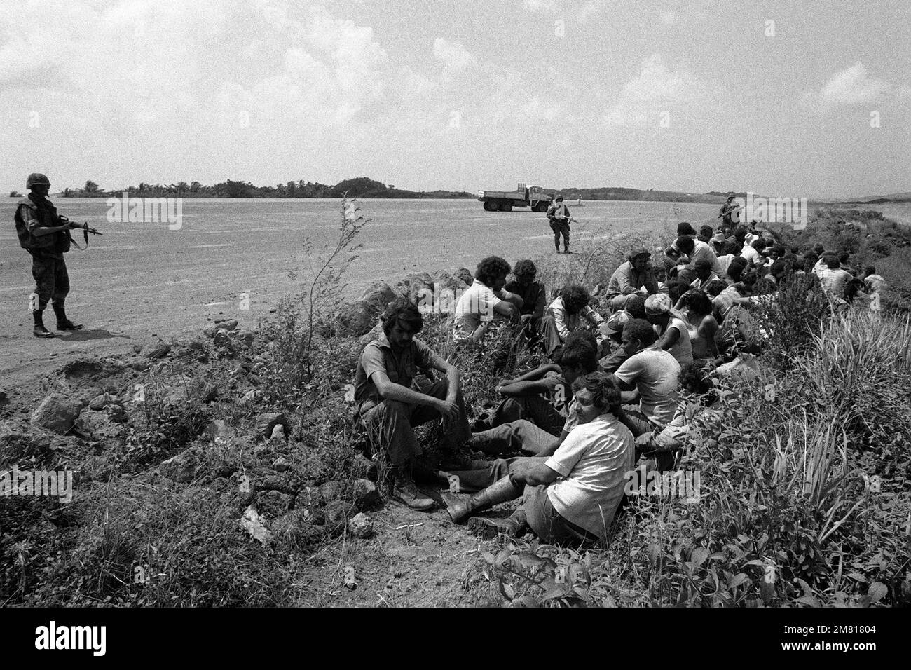 Members of the 82nd Airborne Division guard a group of Cuban nationals ...