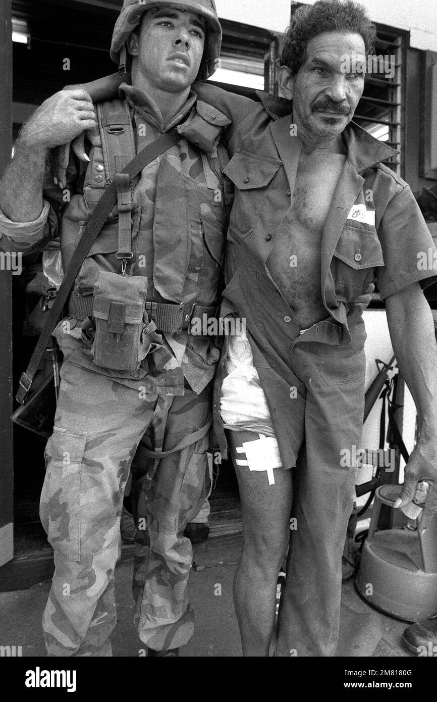 A member of the 82nd Airborne Division assists a Cuban national who was ...