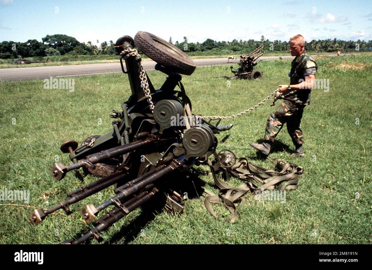A soldier attaches hoisting straps and chains to a Cuban ...