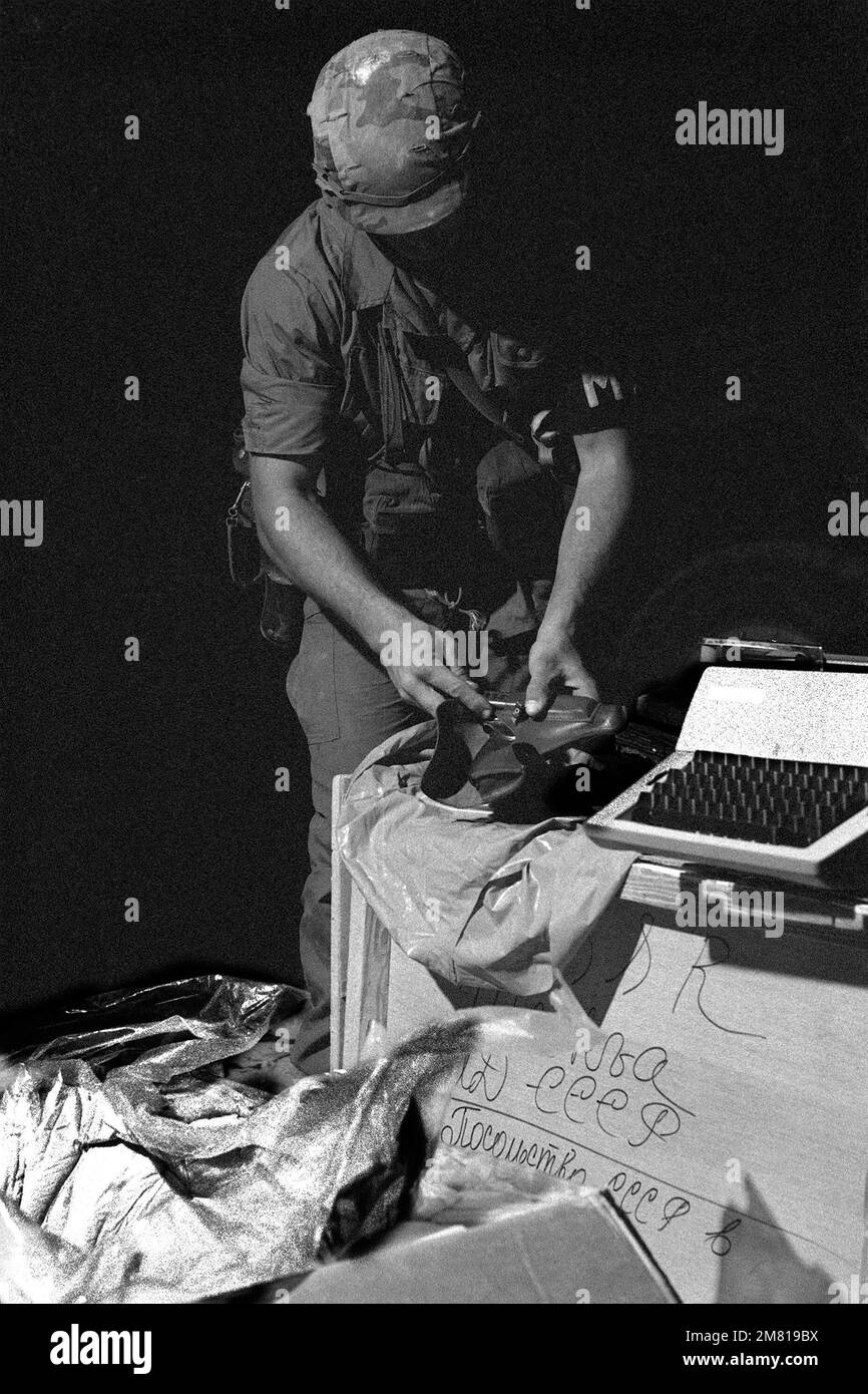 An 82nd Airborne Division military policeman examines a pistol seized ...