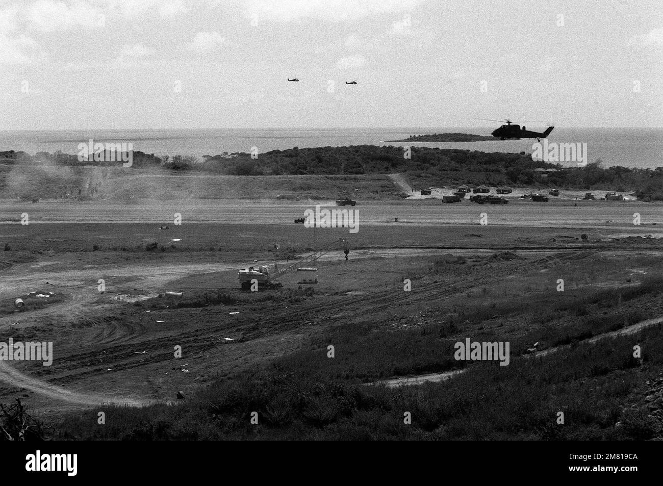 Helicopters fly over the Point Salines Airfield runway during the ...