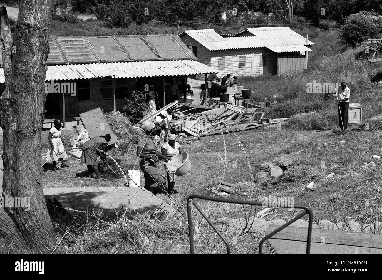 Grenadians clean up outside a building near the US Joint Detention ...