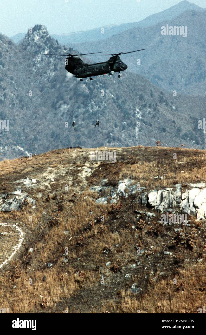 Two members of a Marine recon team rappel from a hovering CH-46 Sea ...