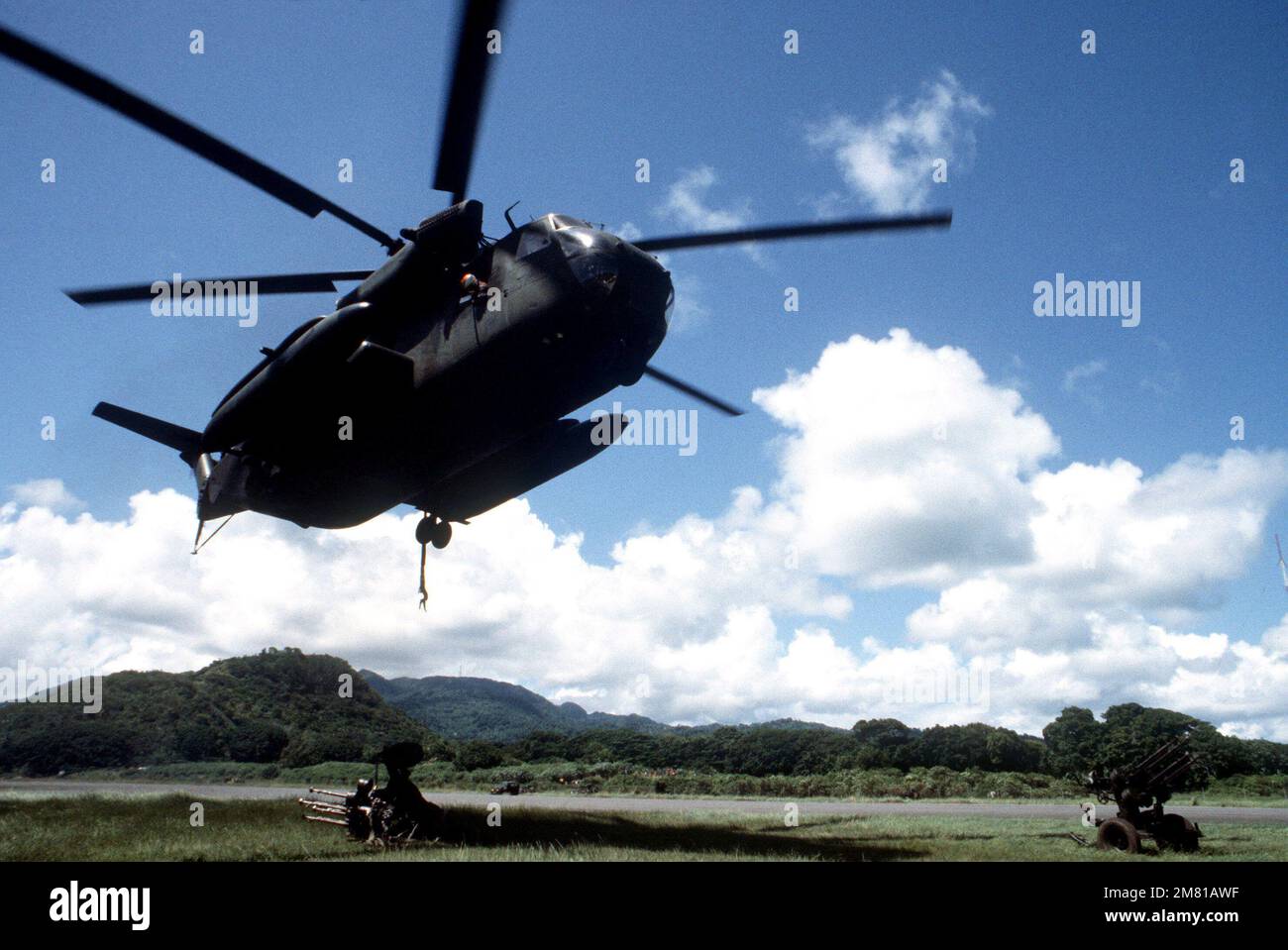 A CH-53 Sea Stallion helicopter hovers above a Soviet M-53 anti ...