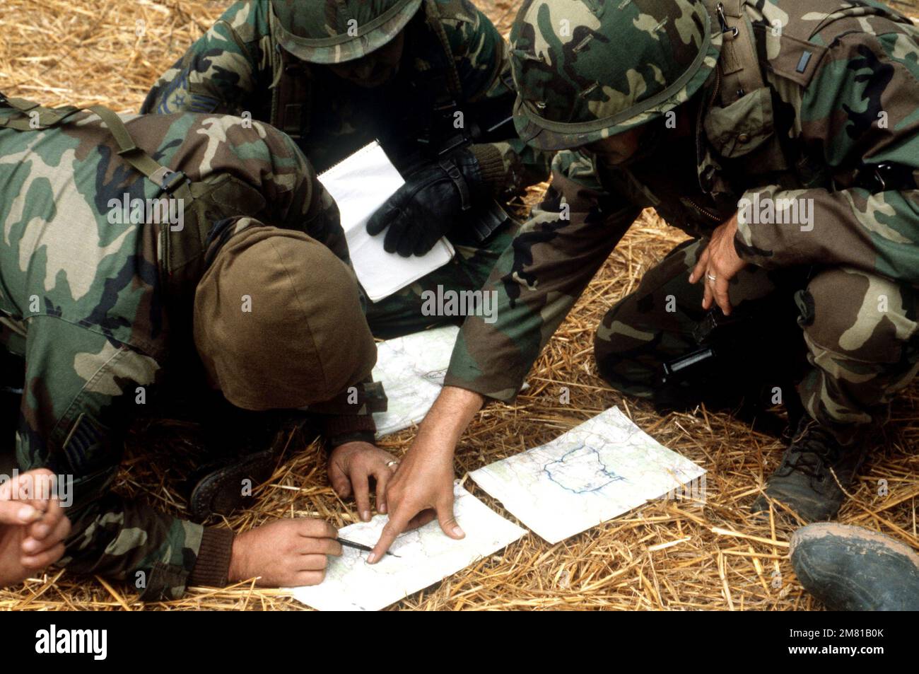 US military personnel use maps to locate key areas on the island during ...