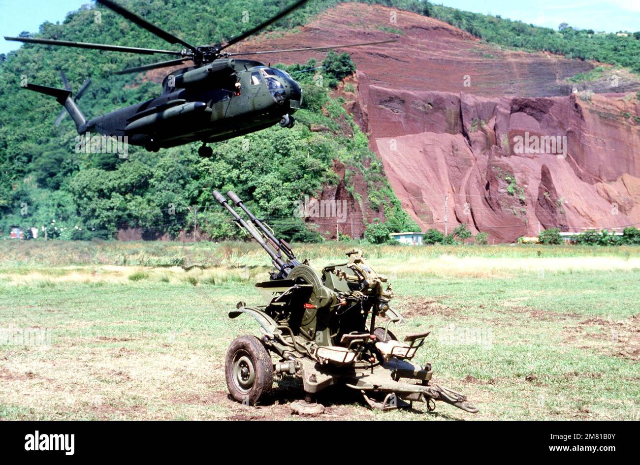 A CH-53 Sea Stallion helicopters hovers above a Soviet ZU-23 anti aircraft gun prior to picking ...