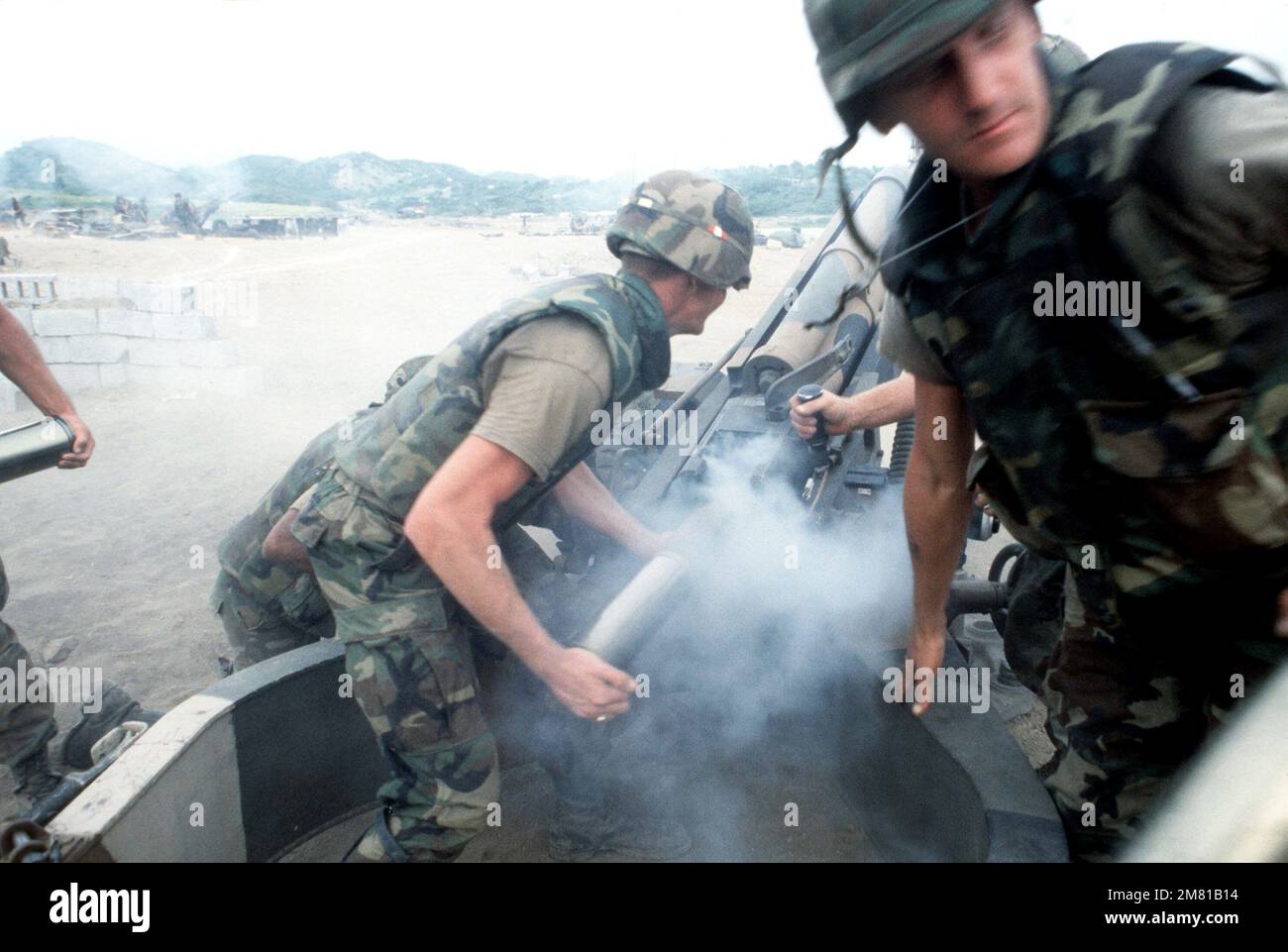 82nd Airborne artillery personnel load and fire M102 105 mm howitzers during Operation URGENT ...