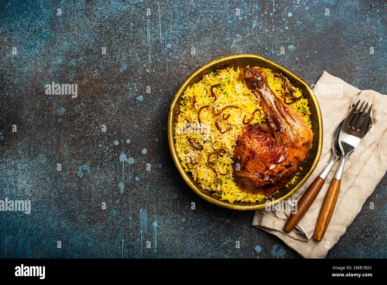 Indian dish Biryani chicken with basmati rice in metal brass old bowl ...