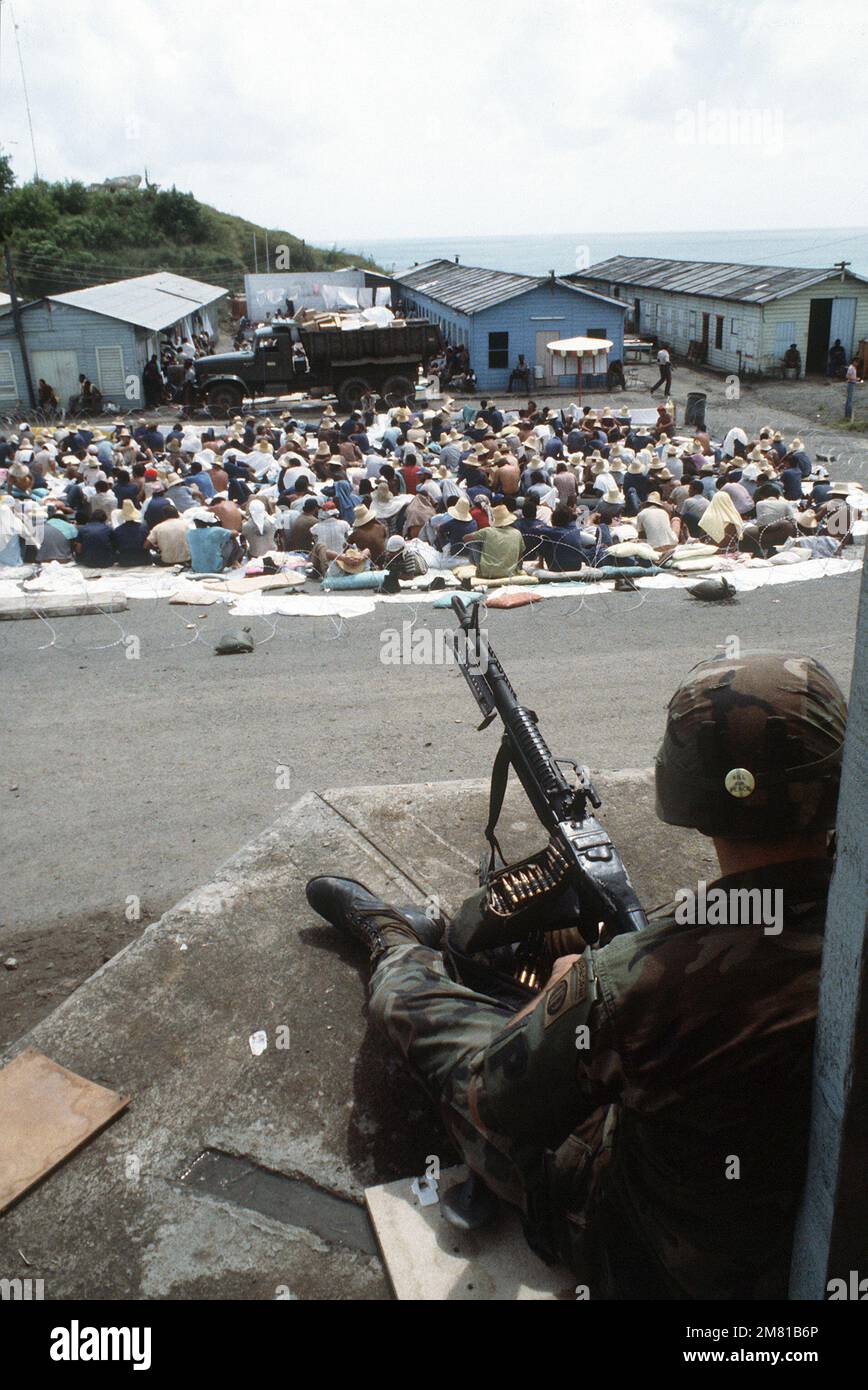 A U.S. serviceman, armed with an M-60 machine gun, guards a group of ...