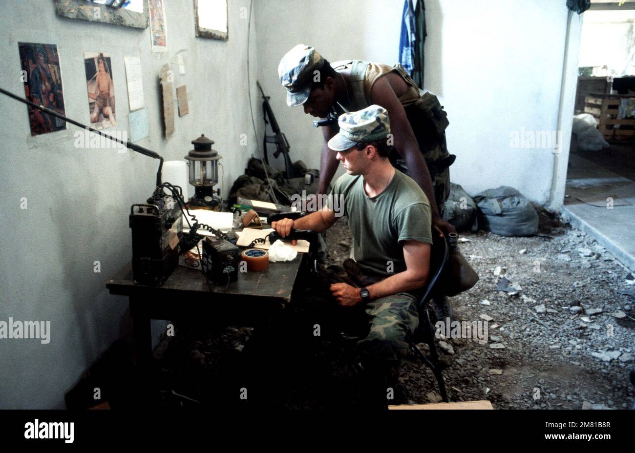 US military personnel set up a field radio inside a building at Point ...