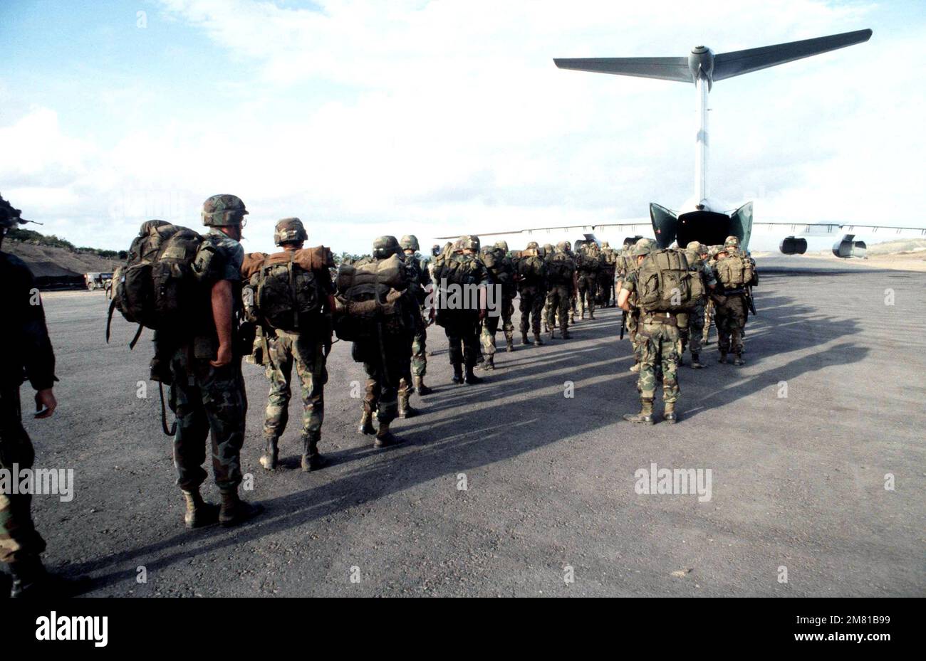 Members of the 82nd Airborne Division board a C-141B Starlifter aircraft during Operation URGENT ...