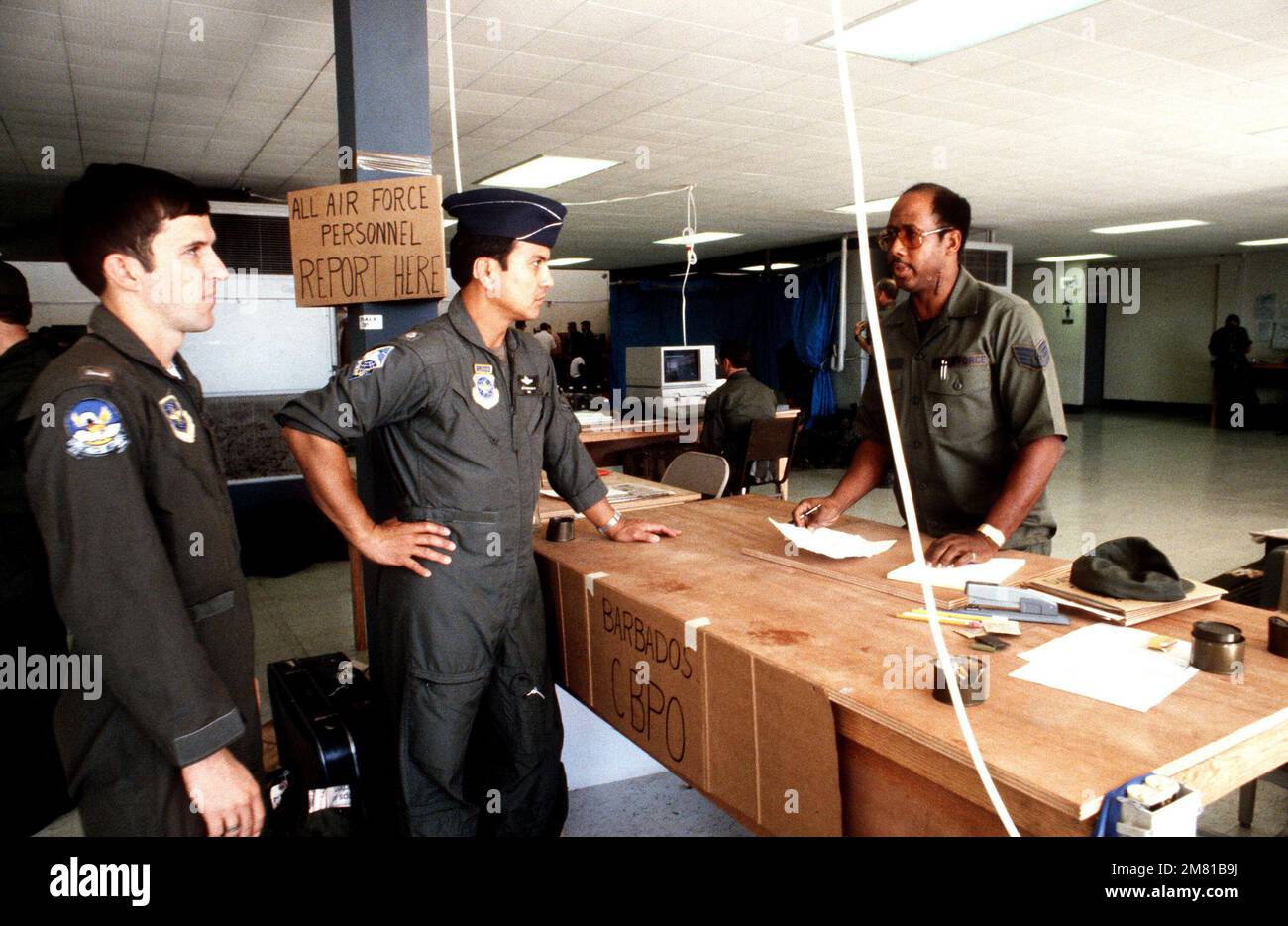 Airmen check in at a personnel desk inside an airport terminal during ...