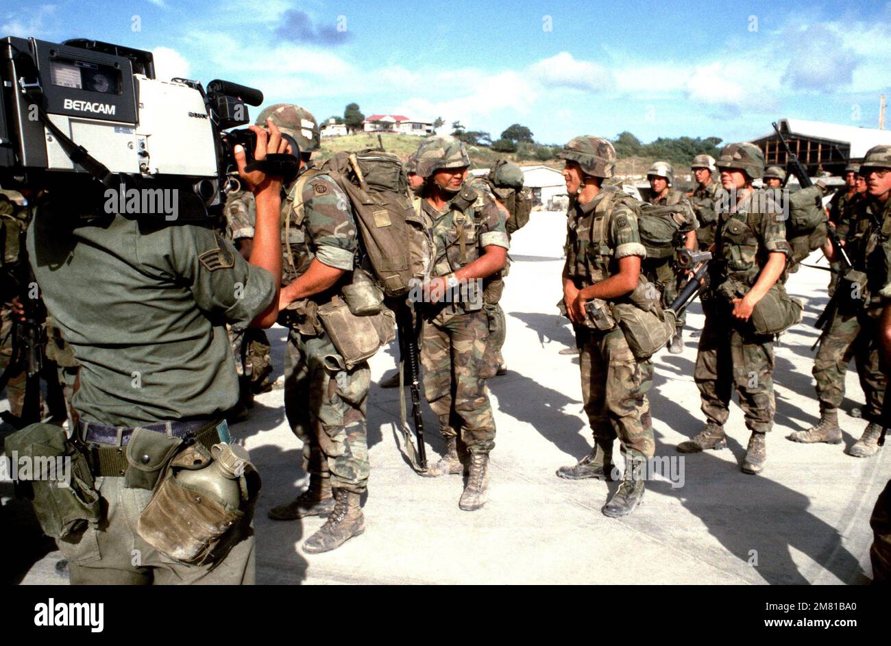 Members of the 82nd Airborne Division are videotaped as they board an aircraft at Point Salines ...