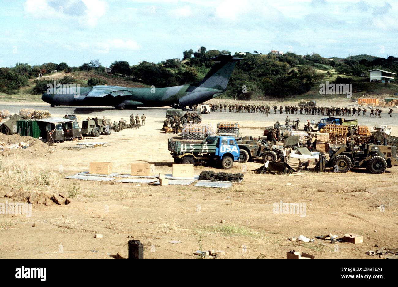 Members of the 82nd Airborne Division board a C-141 Starlifter aircraft at Point Salines Airport ...