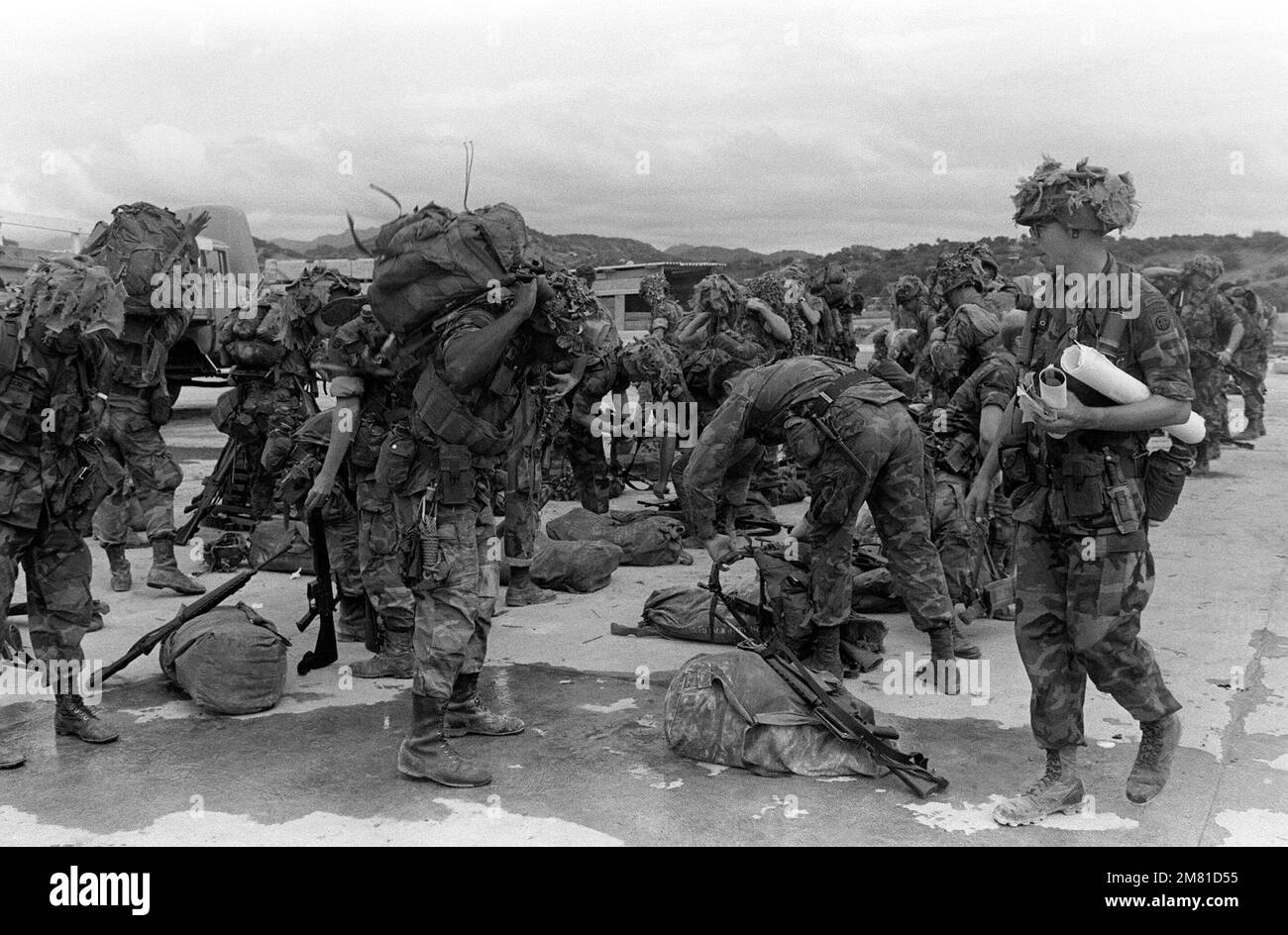 US military personnel pick up their gear prior to boarding a C-130 ...