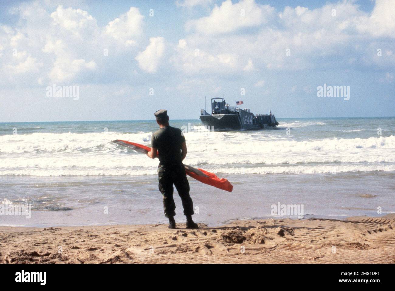 A Marine watches as a utility landing craft approaches Green Beach ...