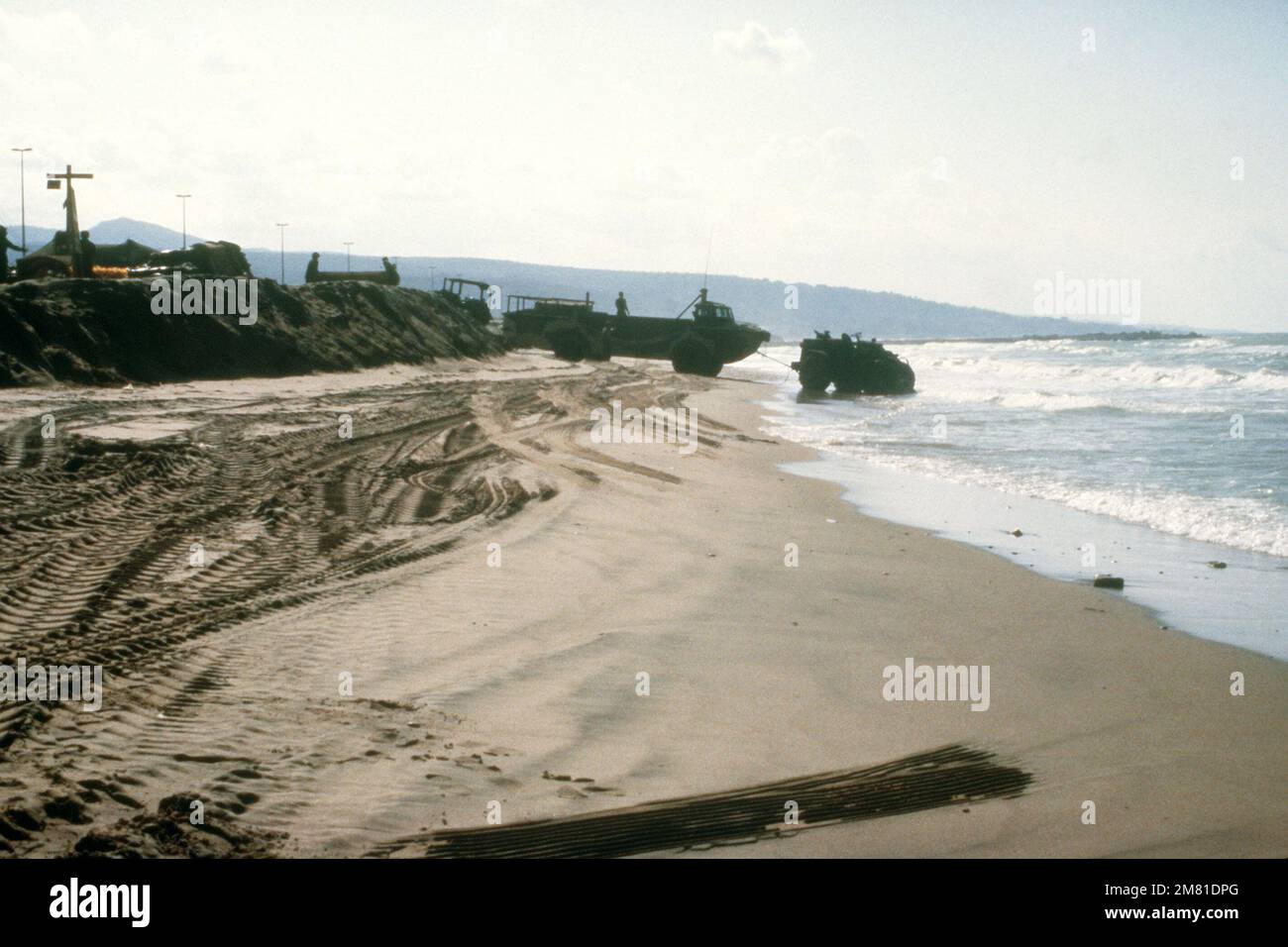 Marine beachmasters prepare an amphibious vehicle for loading aboard a ...