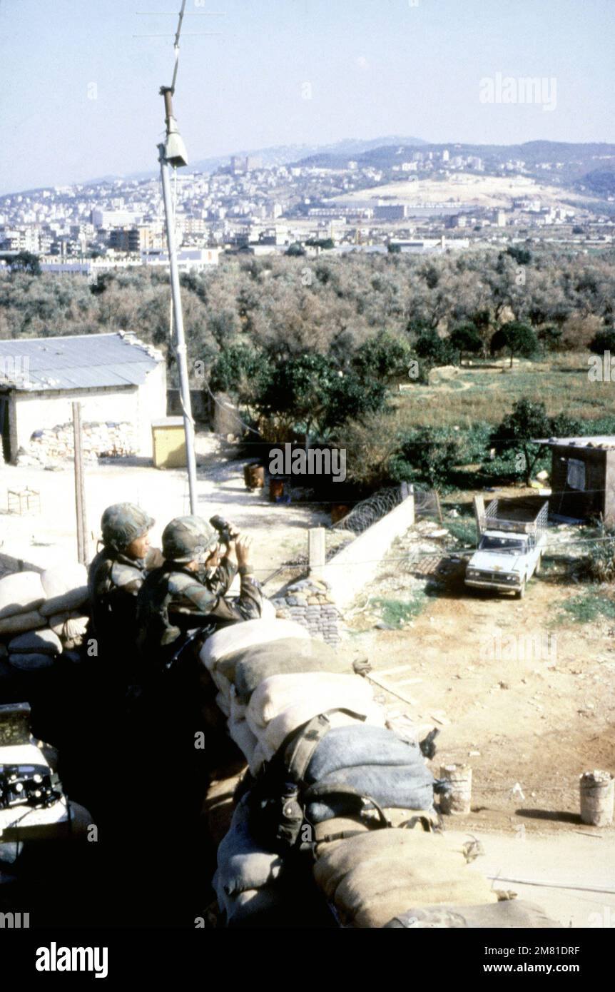 Two Marines observe the surrounding area from their rooftop bunker ...