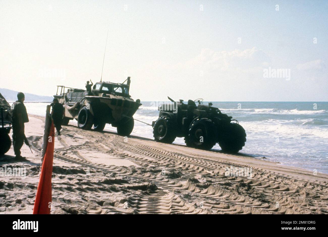 Marine beachmasters prepare an amphibious vehicle for loading aboard a ...