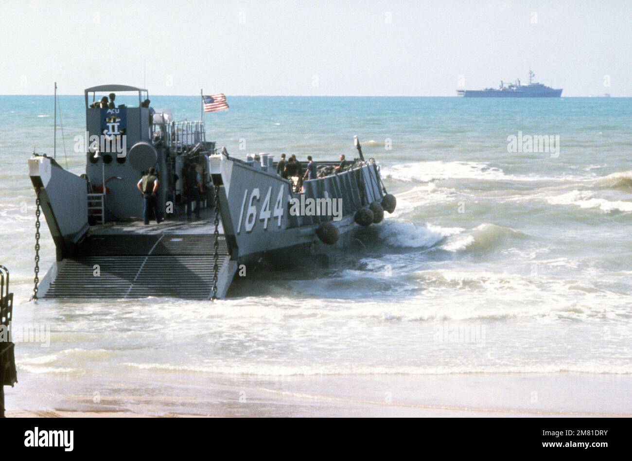 Marine beachmasters prepare to load equipment aboard utility landing ...