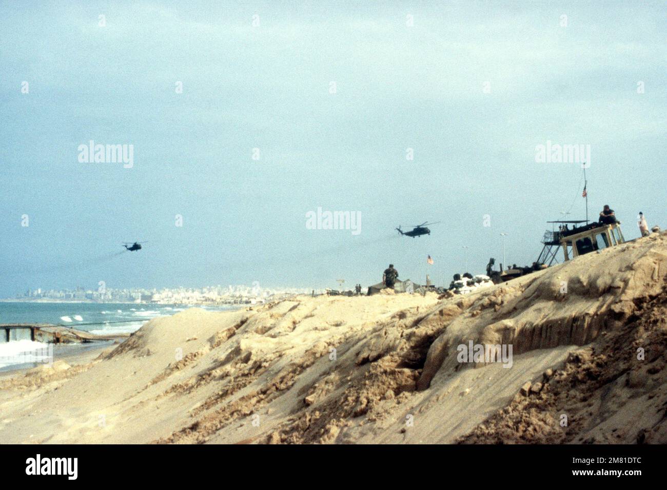 Two Marine helicopters fly over Beachmaster Unit 2 headquarters located ...