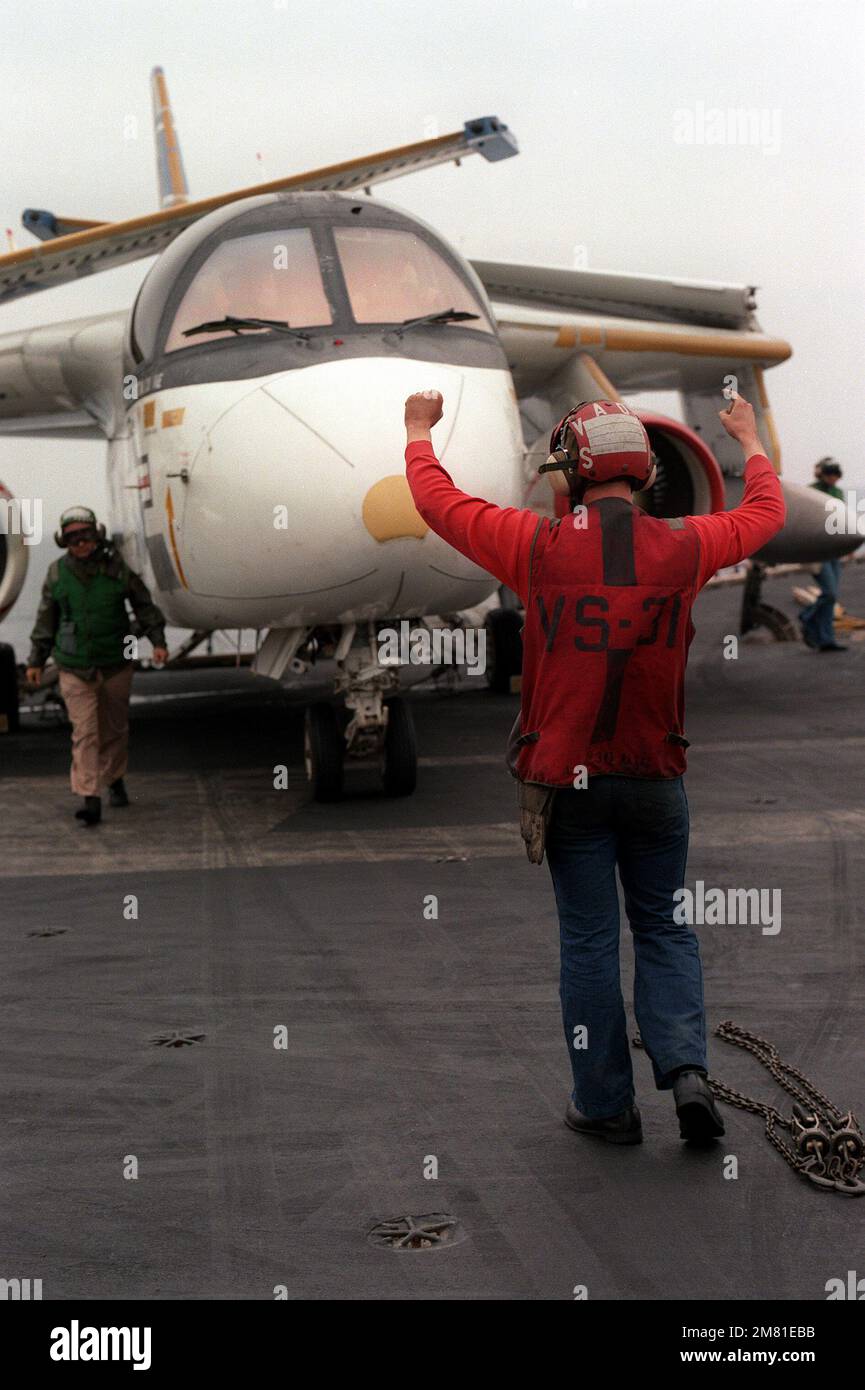 A crewman from Air Anti-submarine Squadron 31 (VS-31) signals to the ...